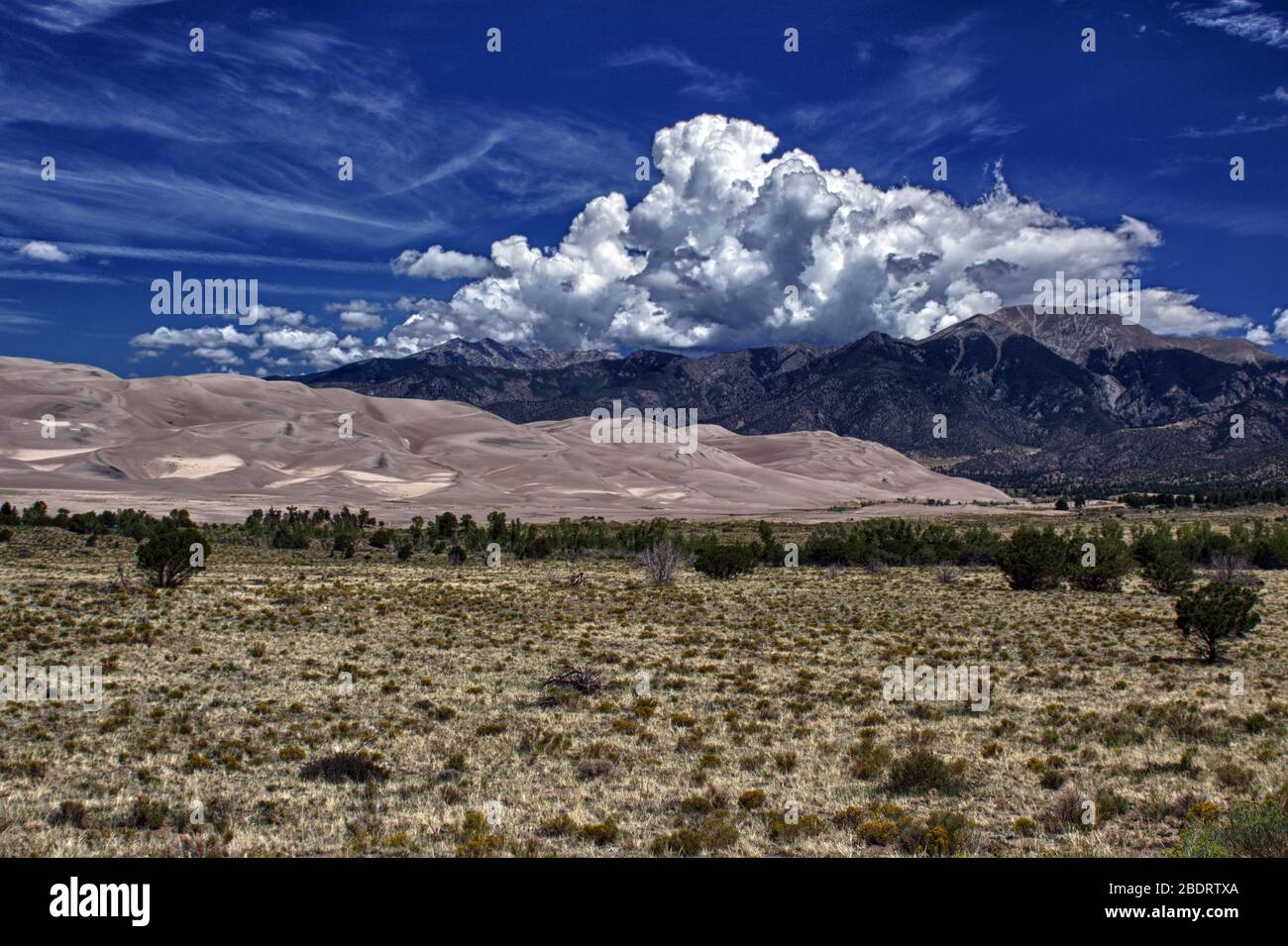 Colorado Sand Dunes contrasting with ground, mountains and sky Stock ...