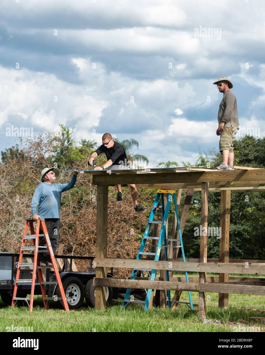 3 men building a barn Stock Photo - Alamy