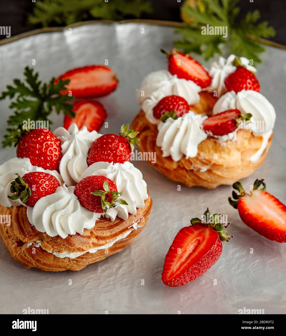 strawberry choux pastry topped with white cream and strawberries Stock ...