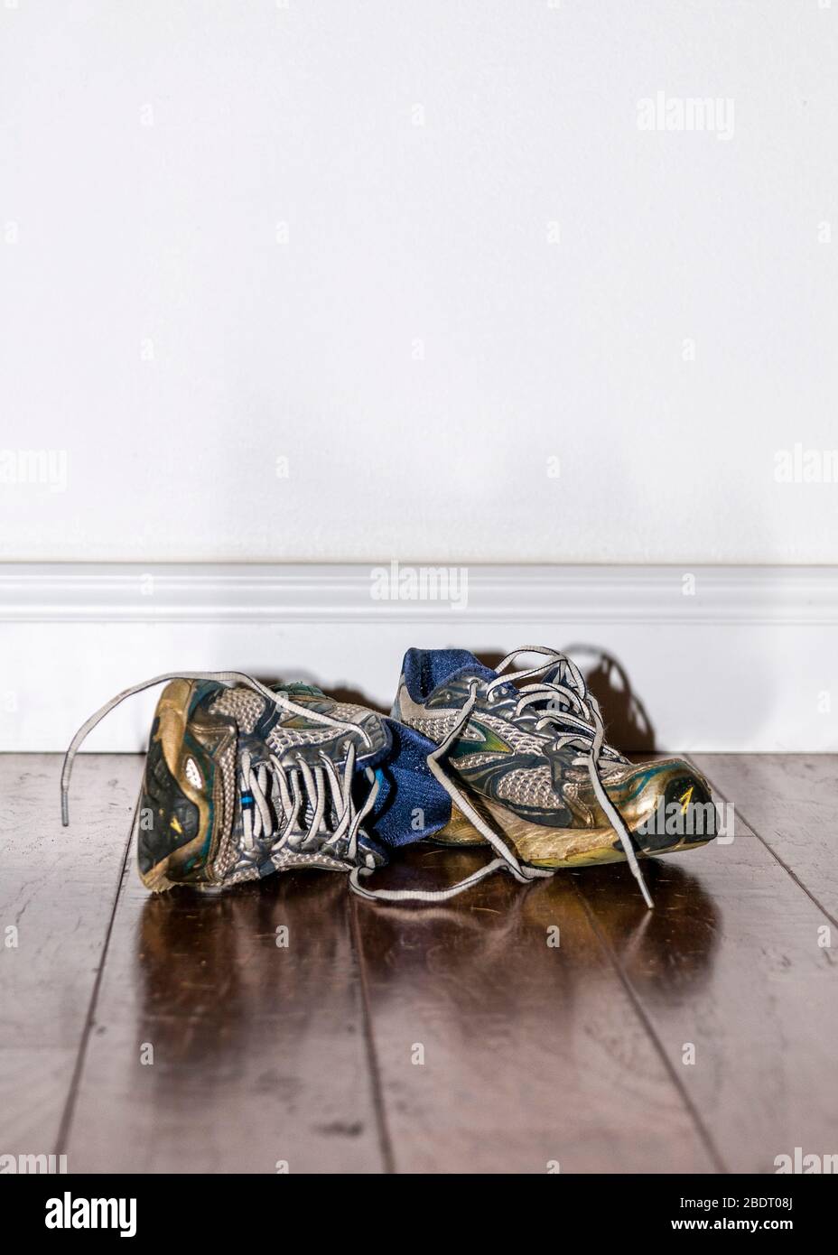 A pair of worn out running shoes on the floor Stock Photo - Alamy