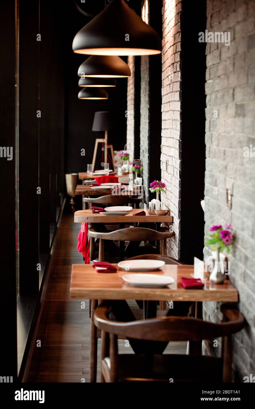 a restaurant corridor with small two people tables Stock Photo - Alamy
