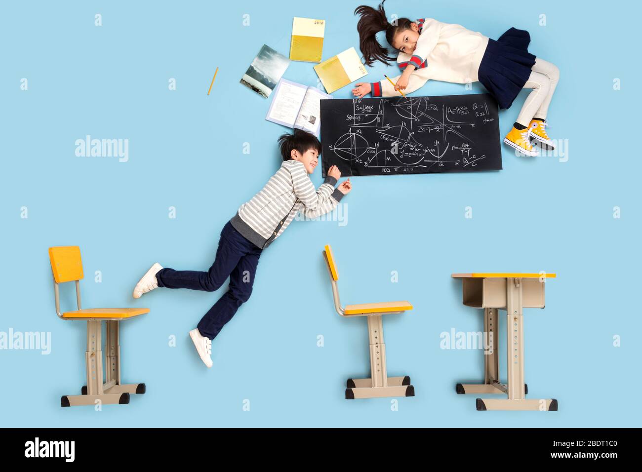 Happy pupils lying to learn math Stock Photo - Alamy