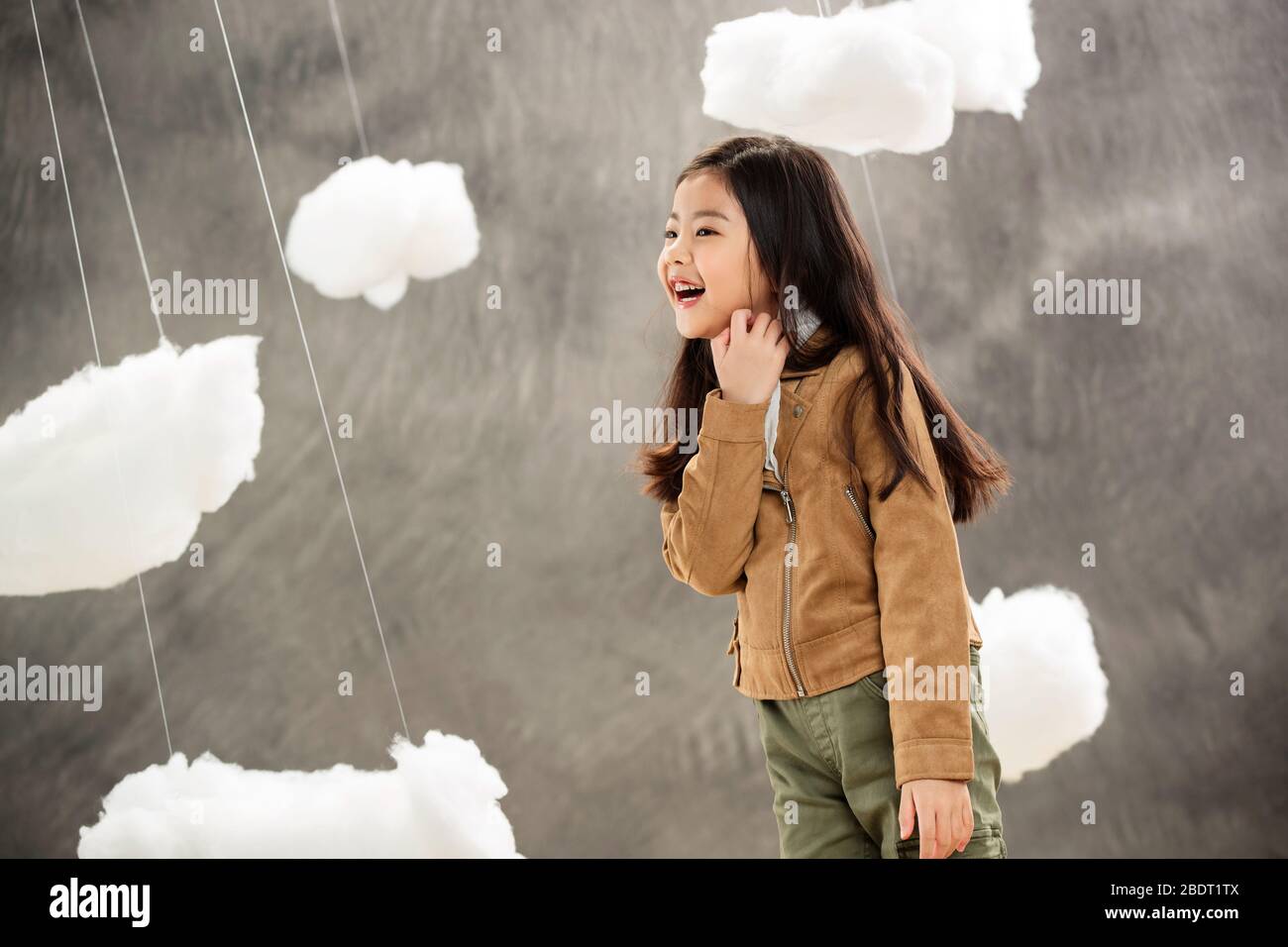 Happy little girl playing in the clouds Stock Photo - Alamy