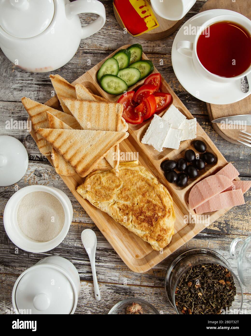 top view of breakfast setup with omelet toast cucumber tomato cheese ...