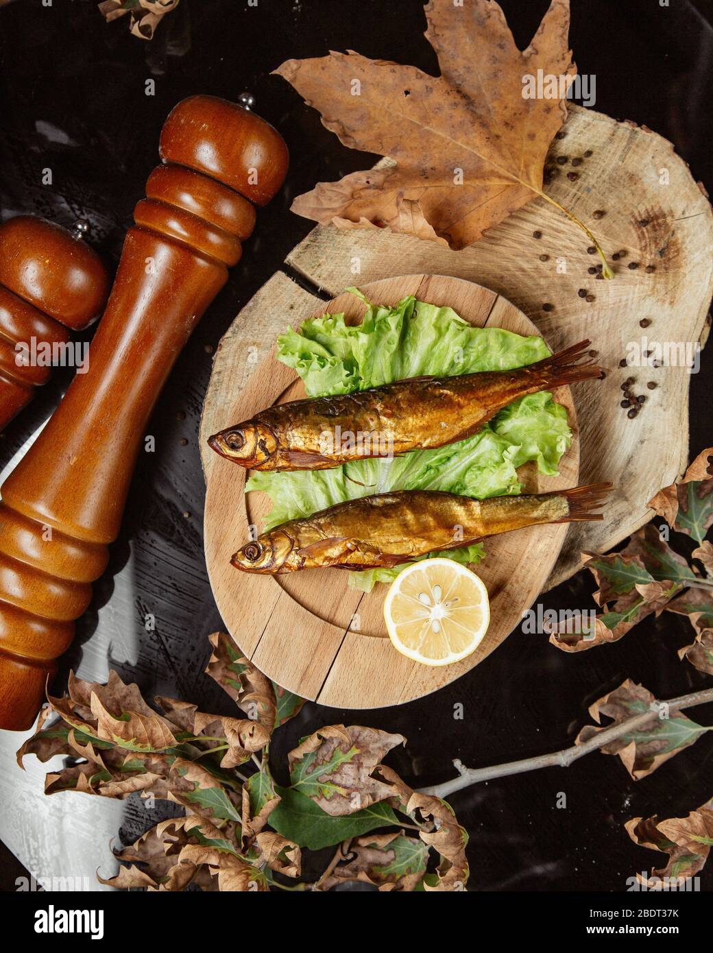 top view of dried smoked fish served with lemon on wooden platter Stock ...