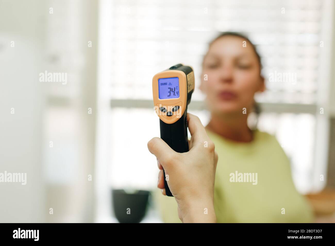 A Doctor checking a woman's temperature with a censor thermometer check ...