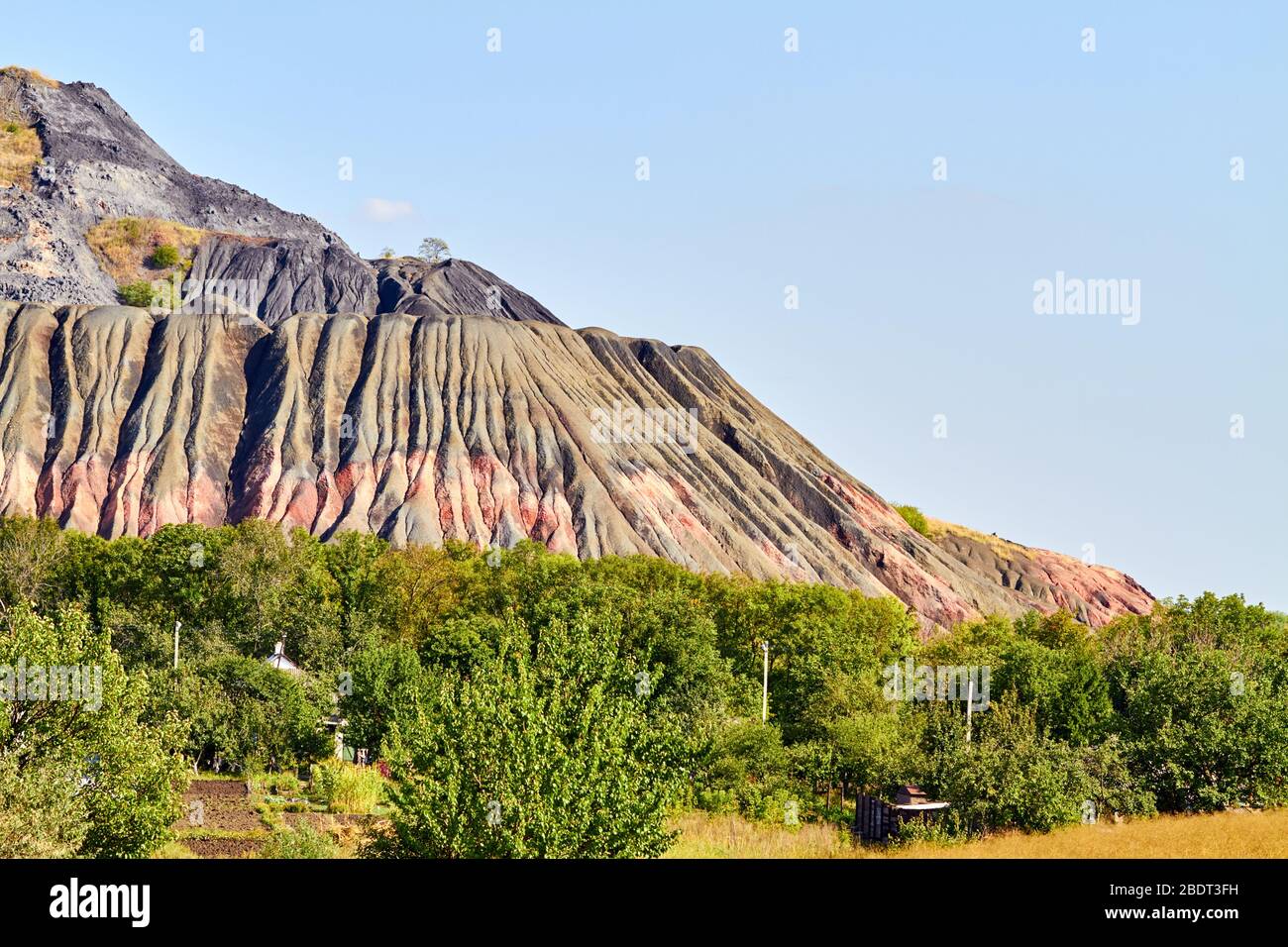 Slagheap in eastern Ukraine with an old house. Industrial waste slag ...