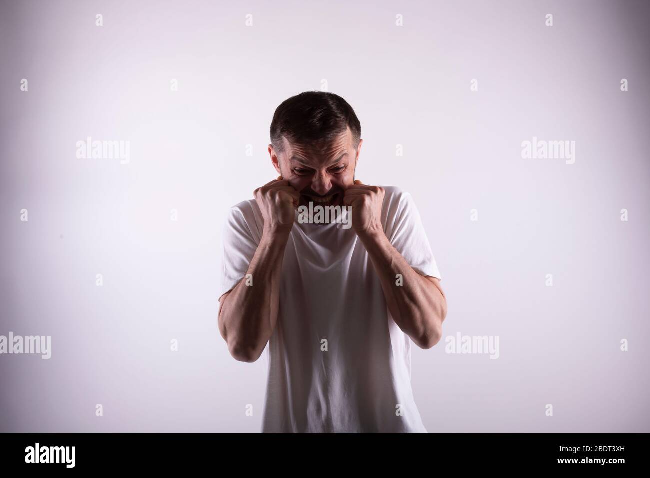 Man in panic attack. Hands at temples, teeth clenched Gambling ...