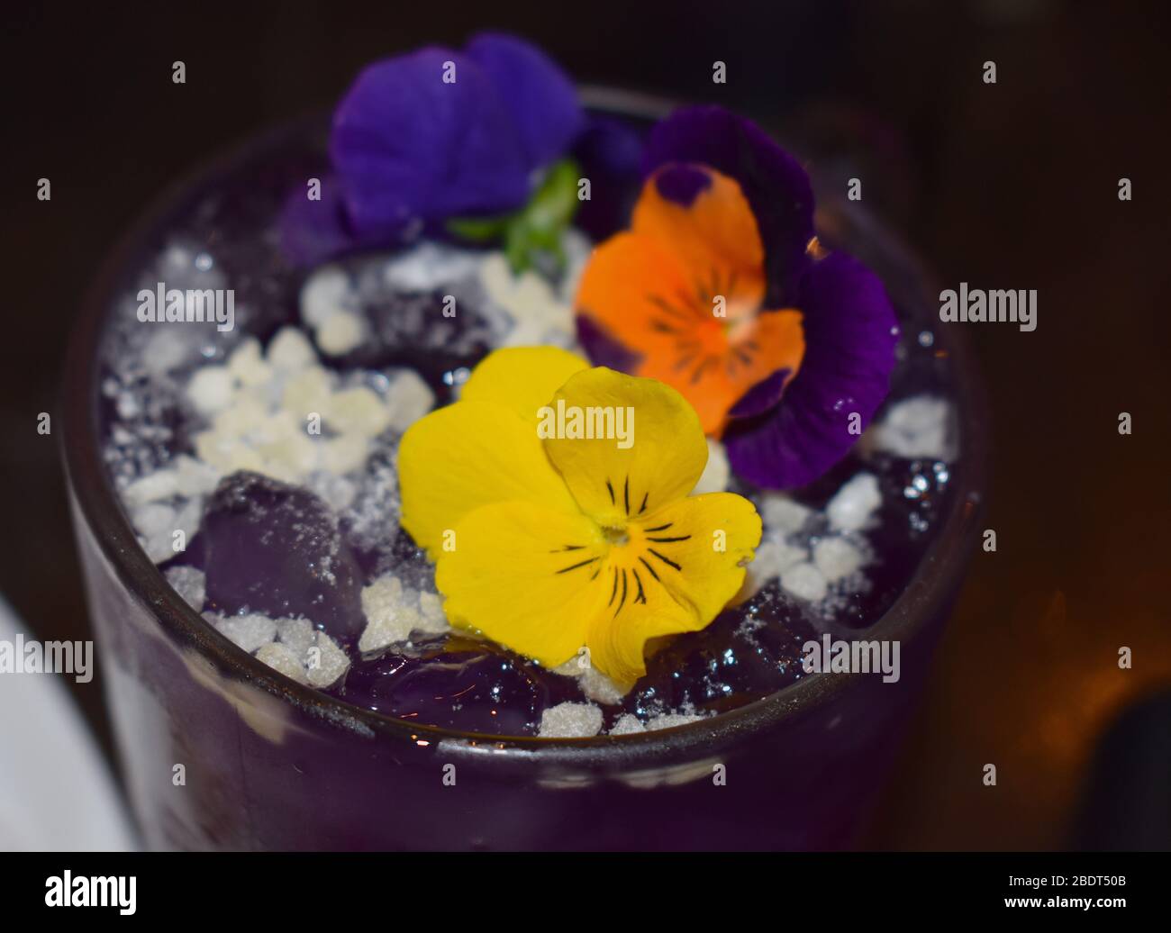 Lemon and vodka cocktail decorated with pansies their smiley faces ...