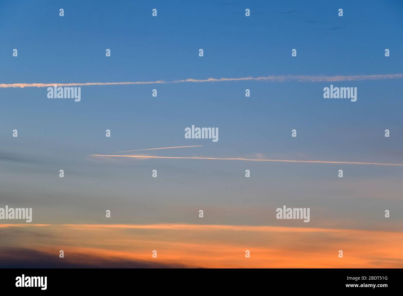 Sunset with condensation trail of an airplane hi-res stock photography ...