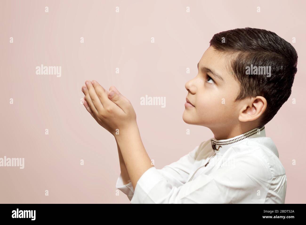 Muslim child praying in the mosque. Little middle-eastern boy prays to ...
