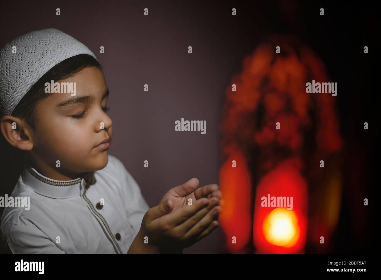 Muslim child praying in the mosque. Little middle-eastern boy prays to ...