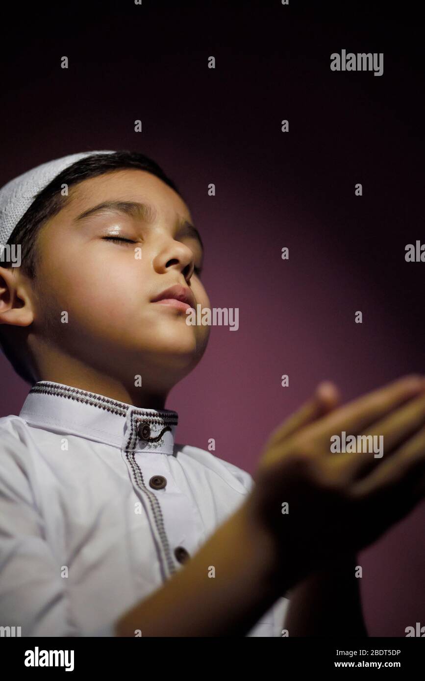 Muslim child praying in the mosque. Little middle-eastern boy prays to ...