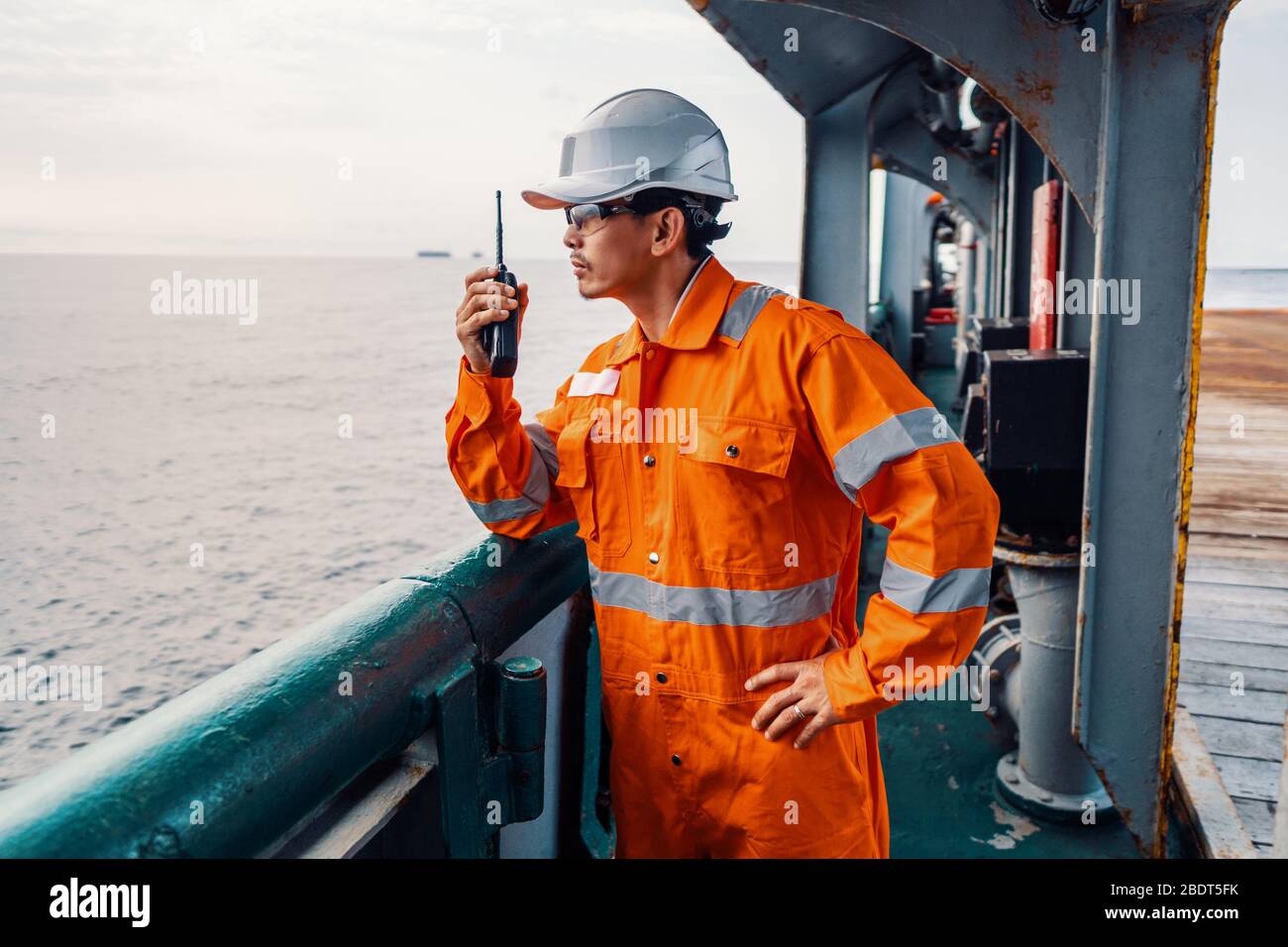 Filipino deck Officer on deck of vessel or ship , wearing PPE personal ...