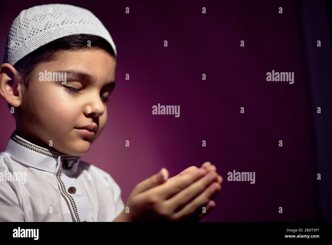 Muslim child praying in the mosque. Little middle-eastern boy prays to ...