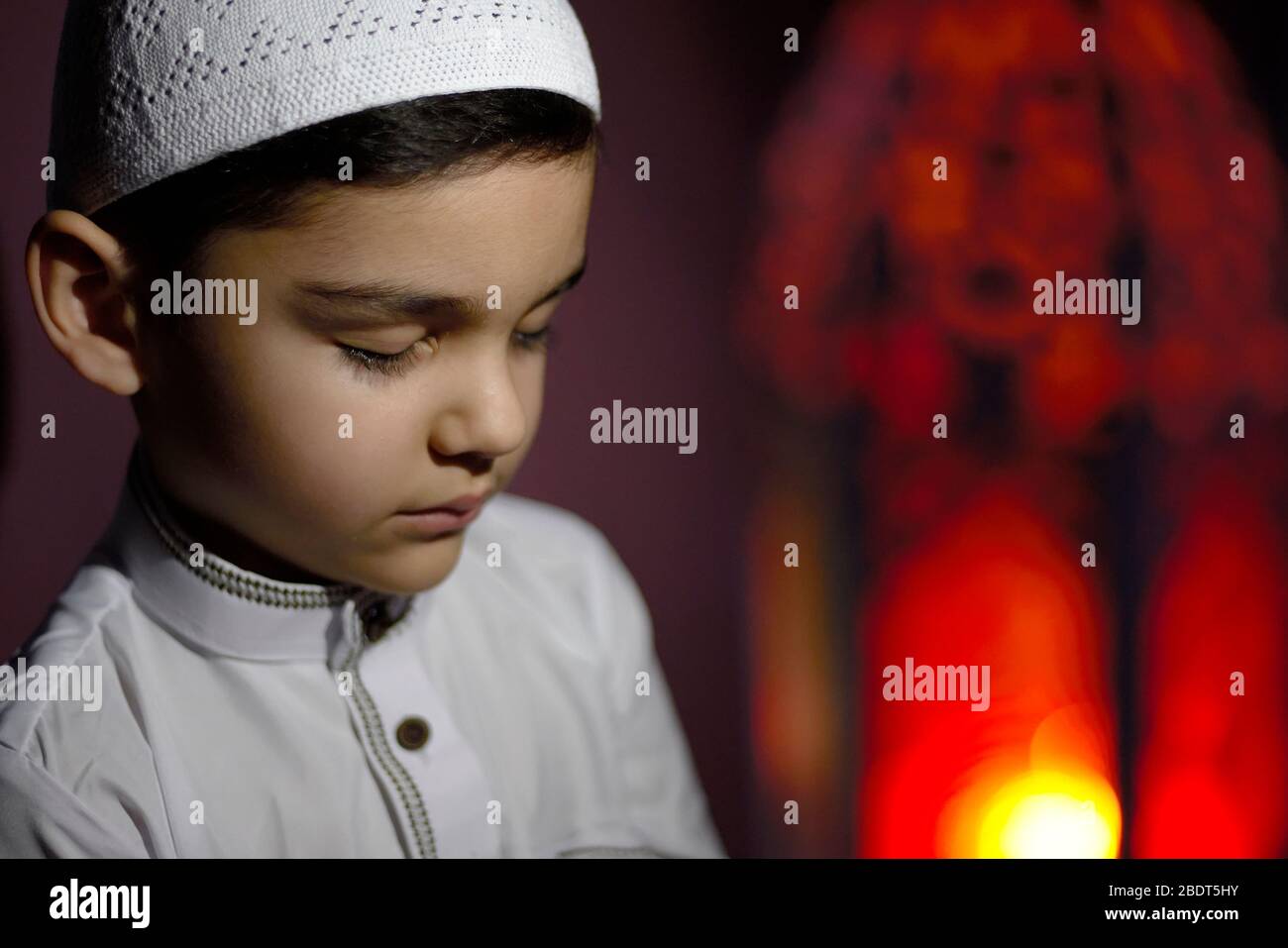 Muslim child praying in the mosque. Little middle-eastern boy prays to ...