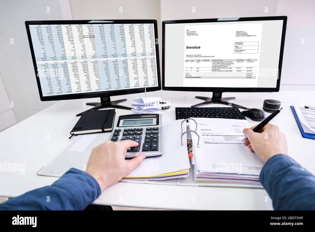 Young Businessman Calculating Bill With Computer And Laptop On Desk ...