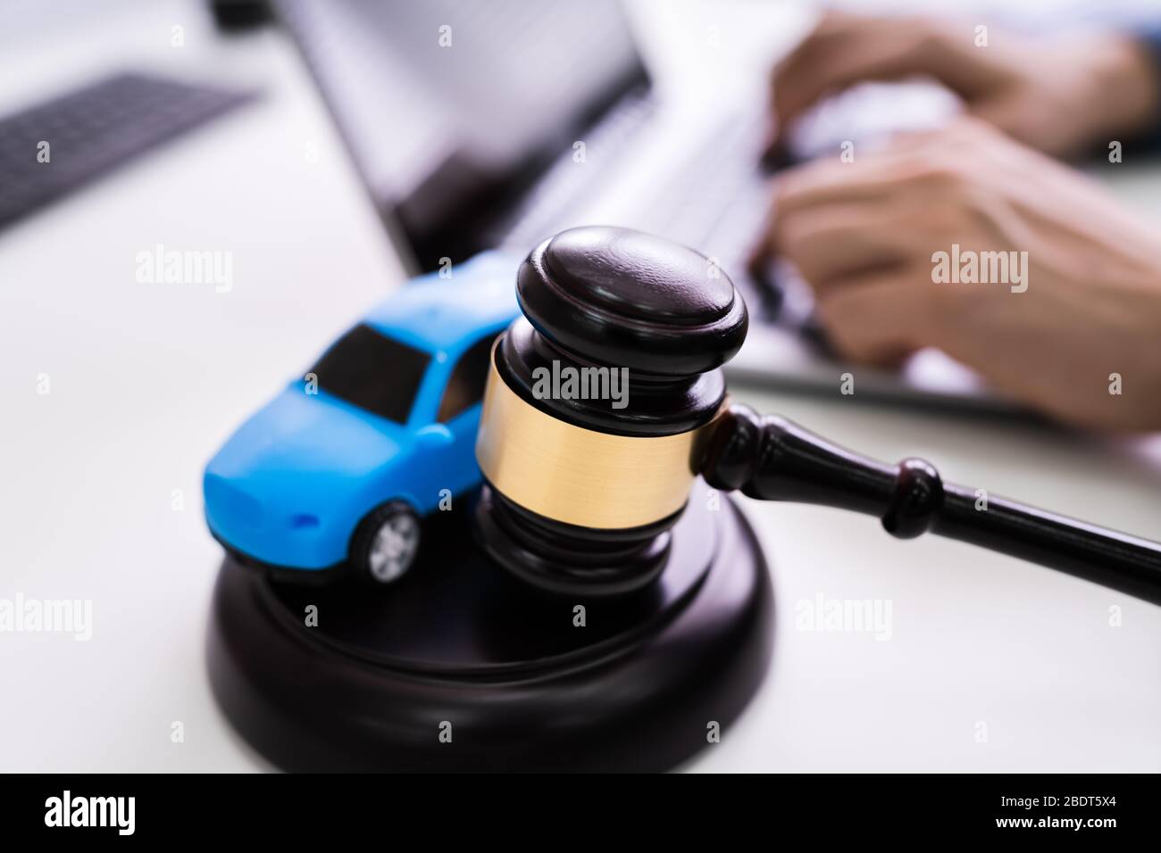 Close-up Of Mallet, Gavel And Blue Toy Car In Front Of A Person Using ...