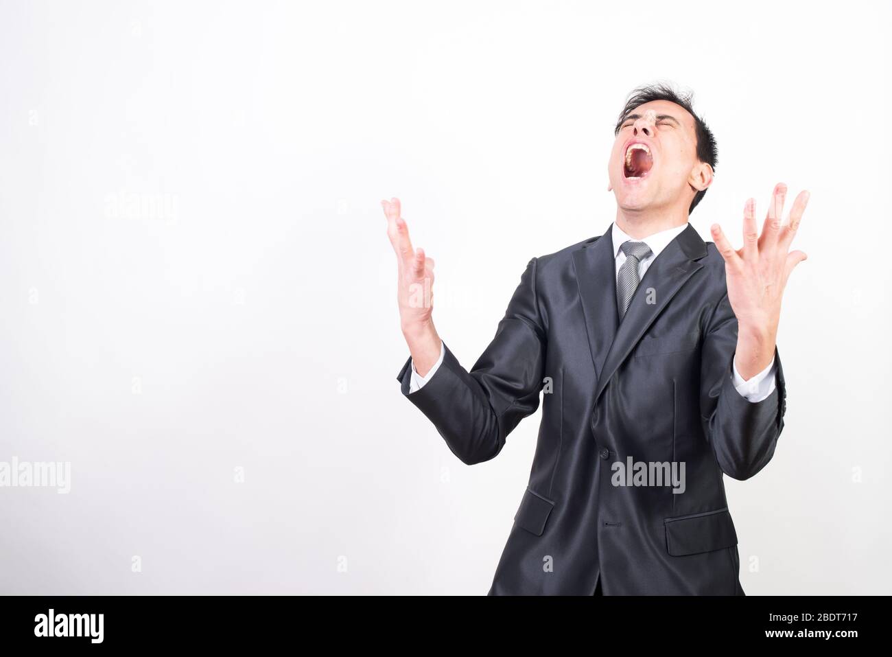 Hysterical man in suit. White background, medium shot Stock Photo - Alamy