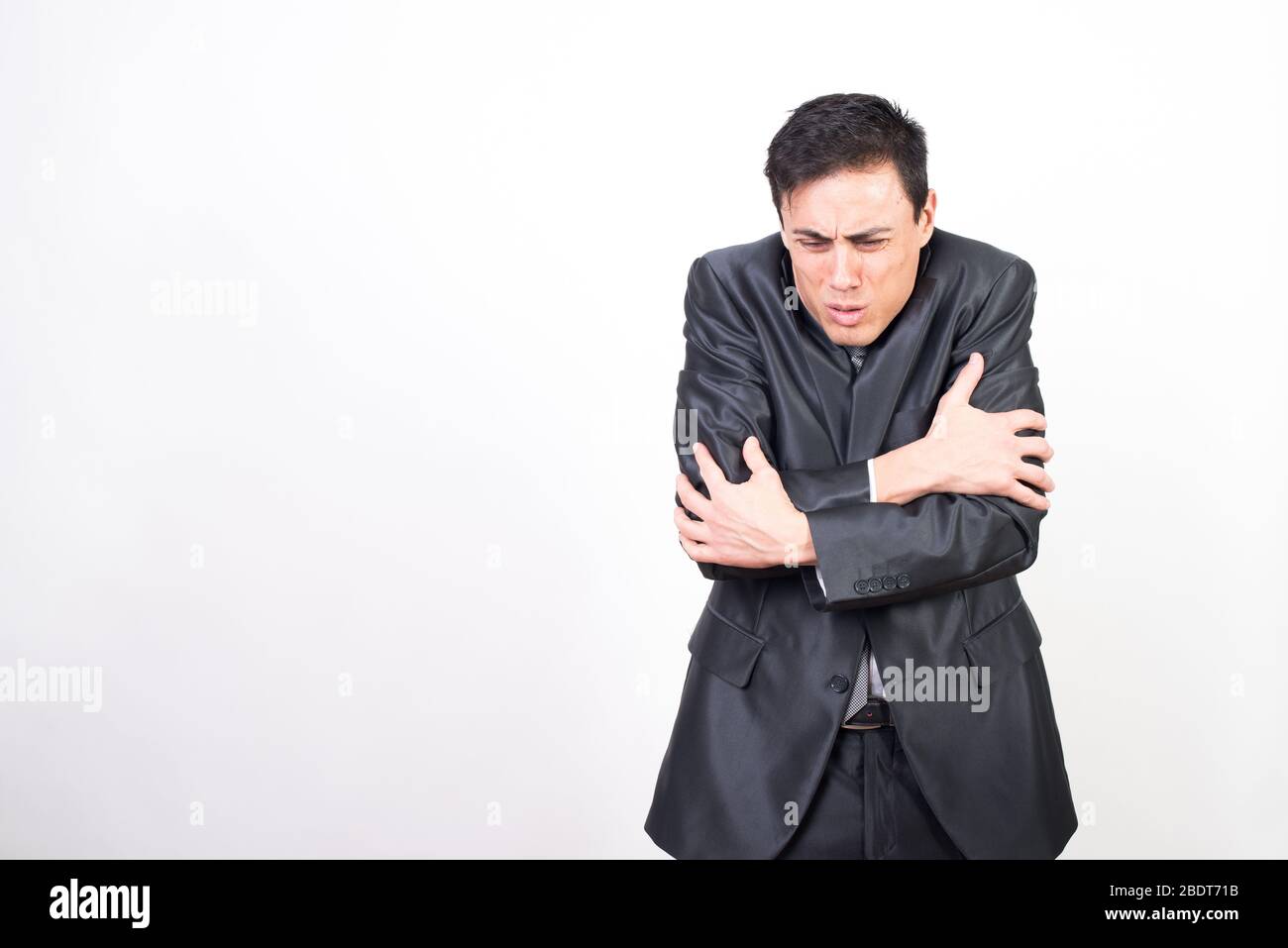 Man in suit getting very cold surrounding his body with his arms. white ...