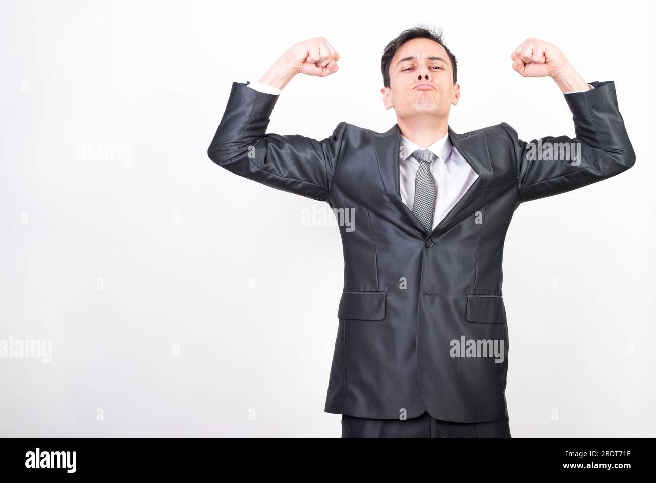 Man in suit pulling out biceps. white background, medium shot Stock ...