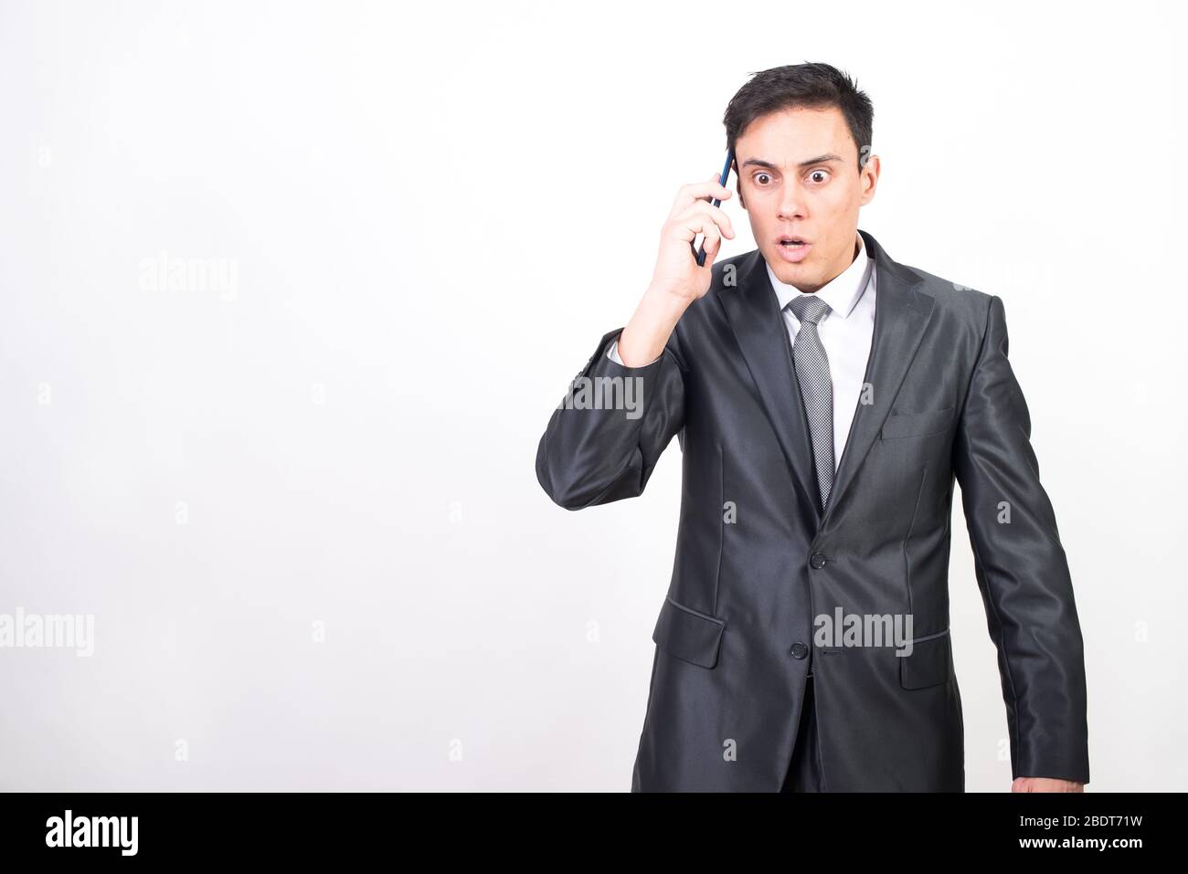 Man in suit talking angry on mobile. White background, medium shot ...