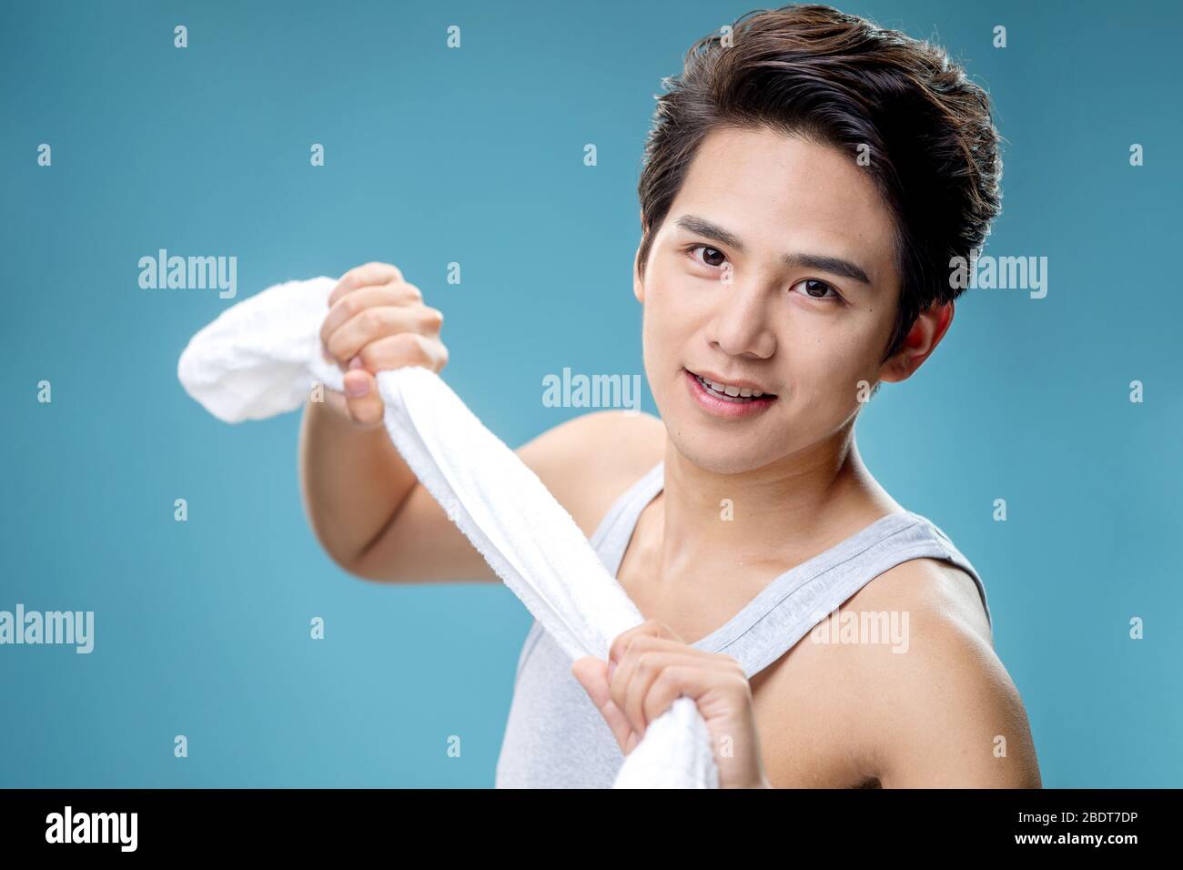 A young man holding a towel Stock Photo - Alamy