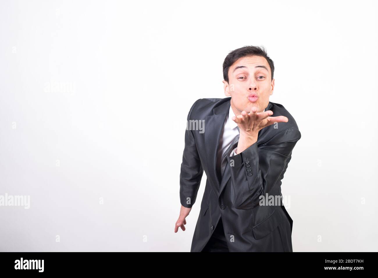 Man in suit throwing a kiss. White background, Medium shot Stock Photo ...