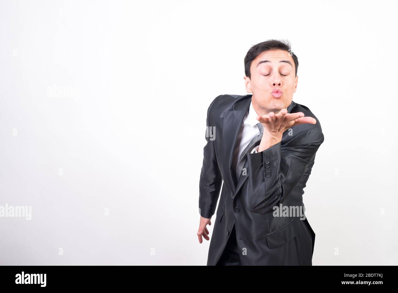 Man in suit throwing a kiss. White background, Medium shot Stock Photo ...