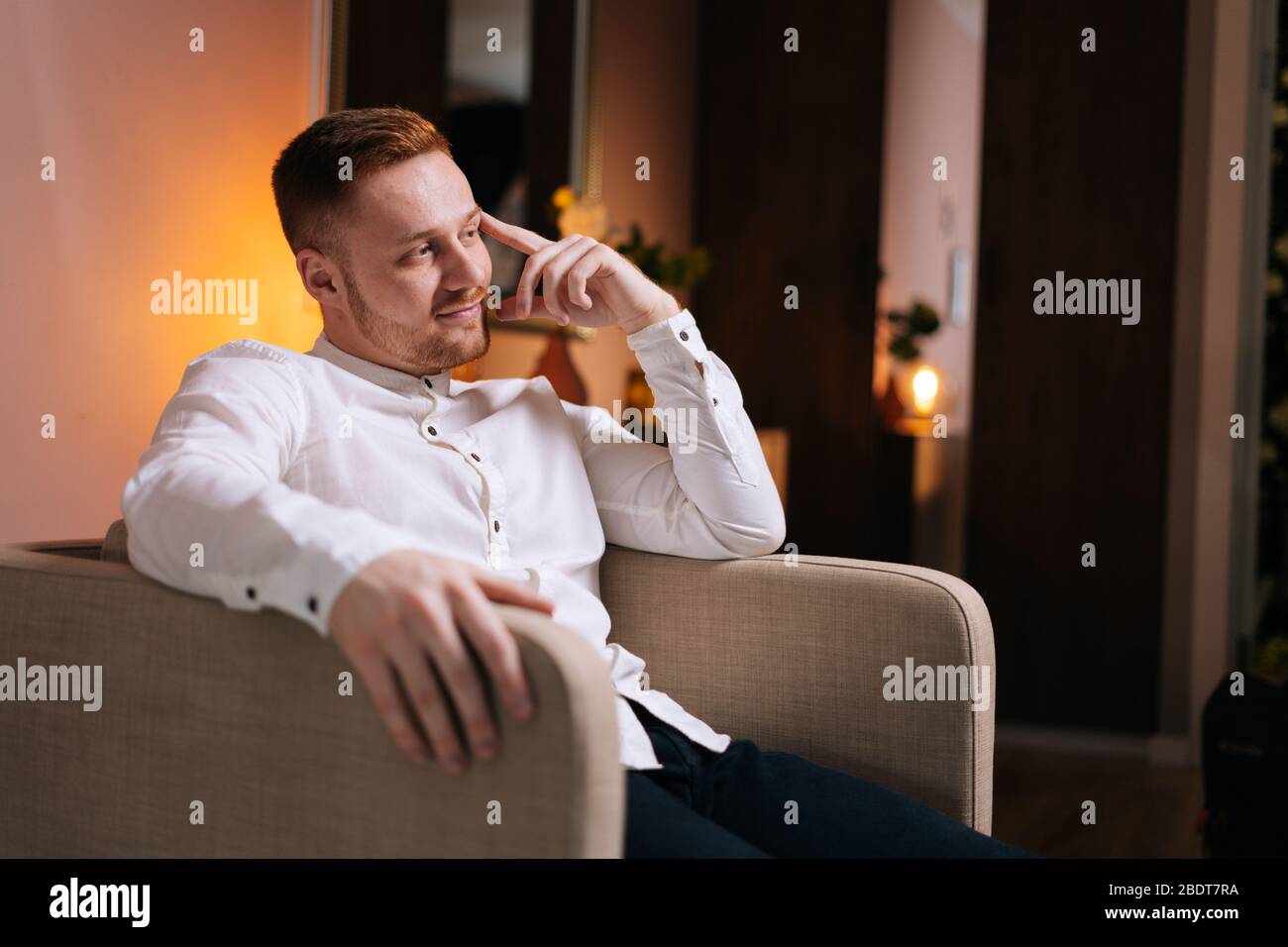 Thoughtful relaxed young man student writer sitting in soft armchair i ...
