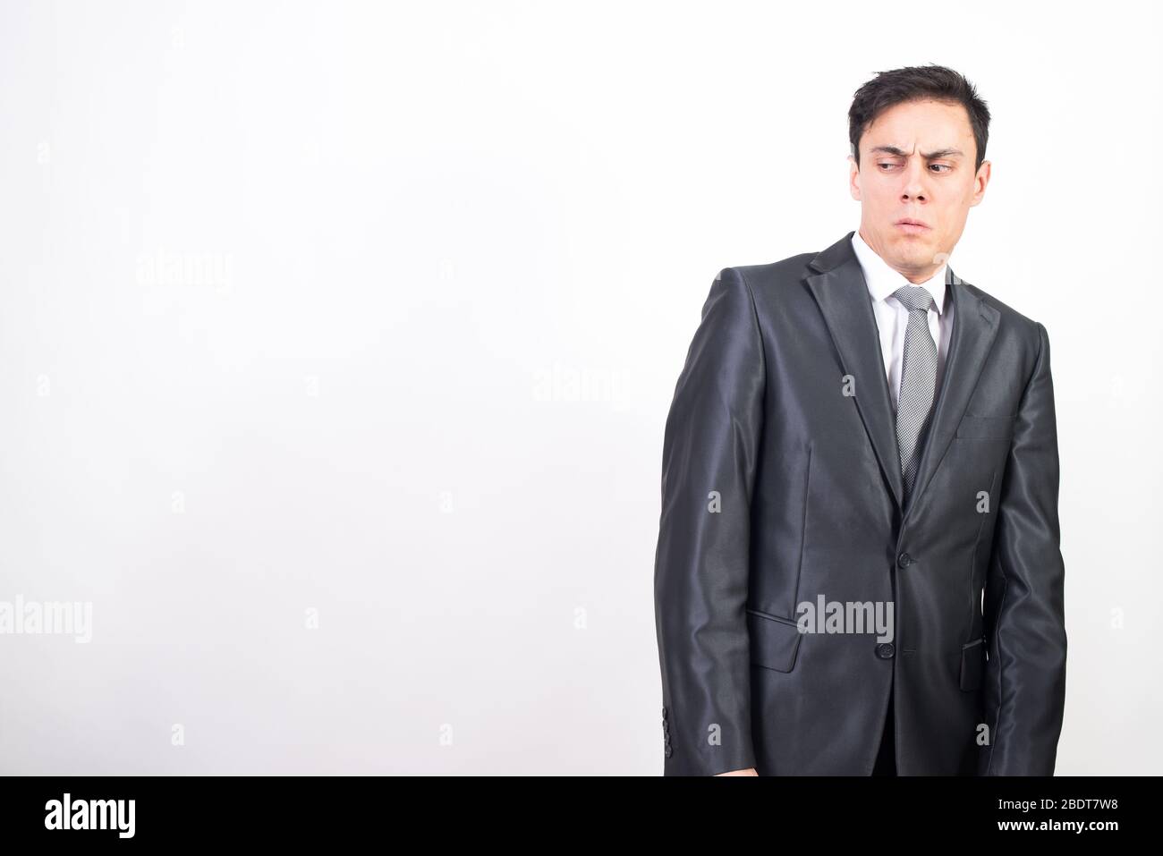 Distrustful man in suit. White background. Middle plane Stock Photo - Alamy