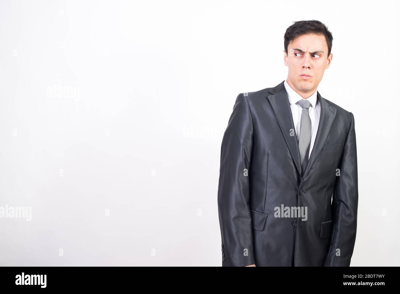 Distrustful man in suit. White background. Middle plane Stock Photo - Alamy