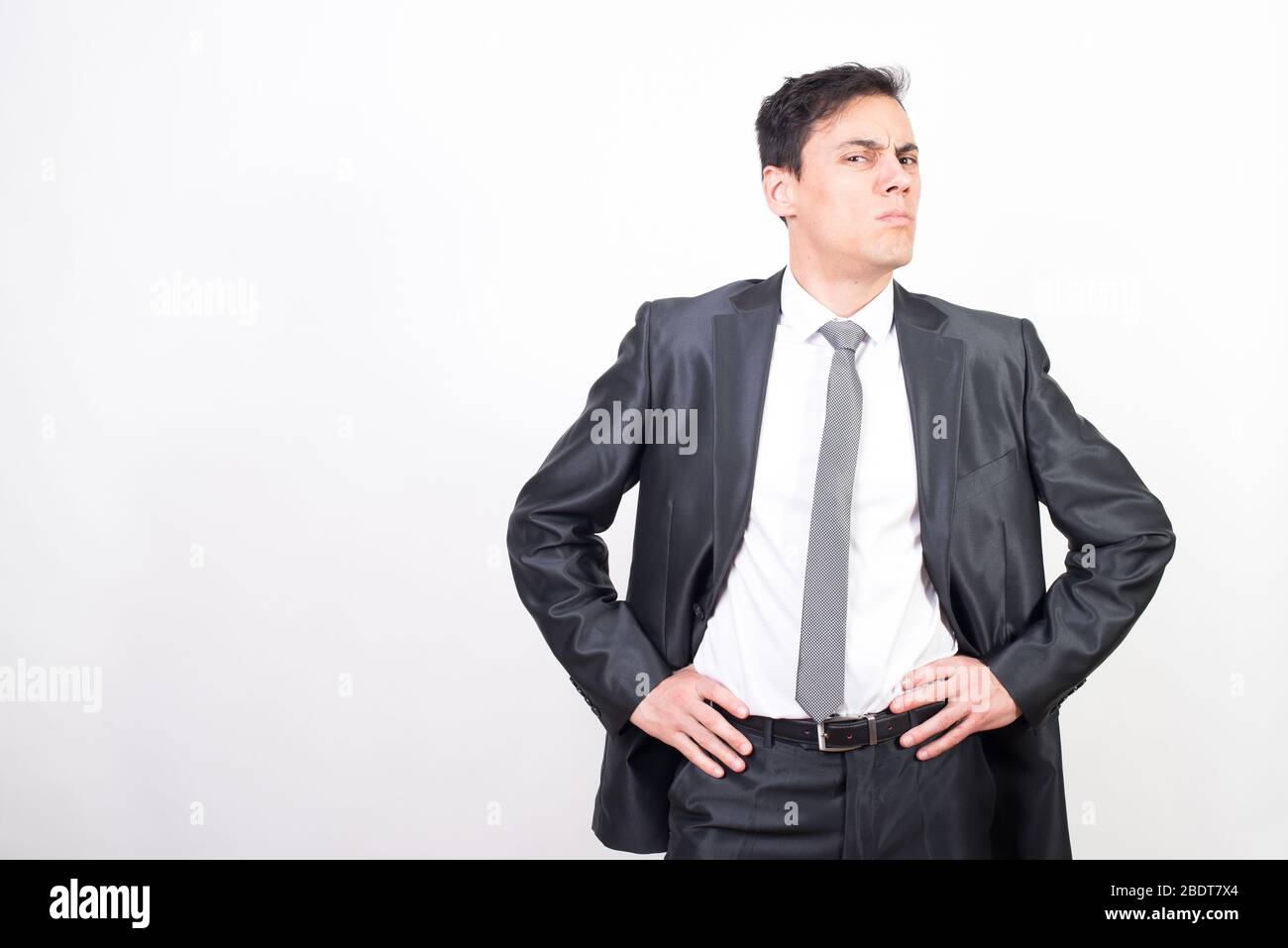 Distrustful man in suit. White background. Middle plane Stock Photo - Alamy