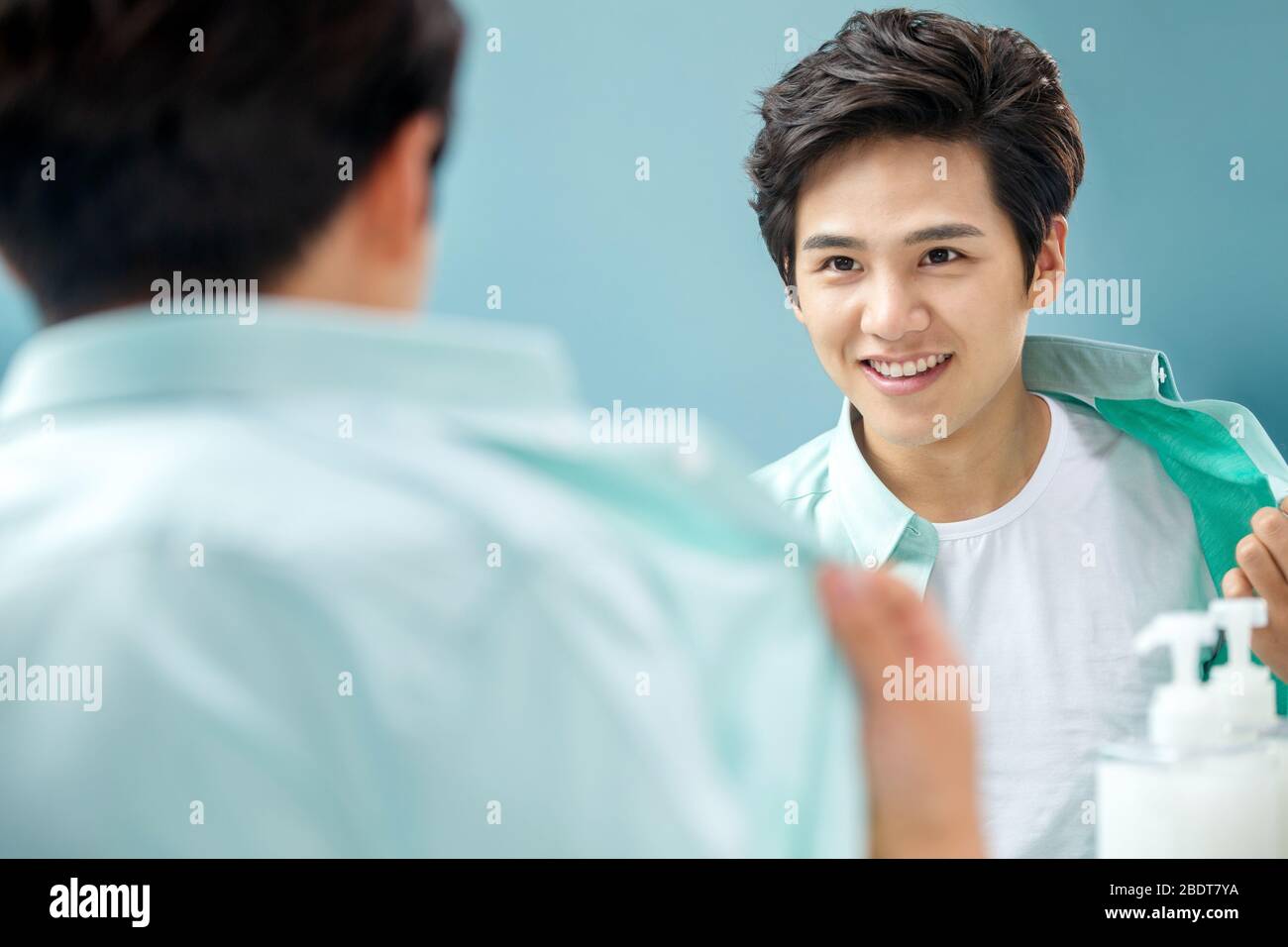 Confident young man look in the mirror Stock Photo - Alamy