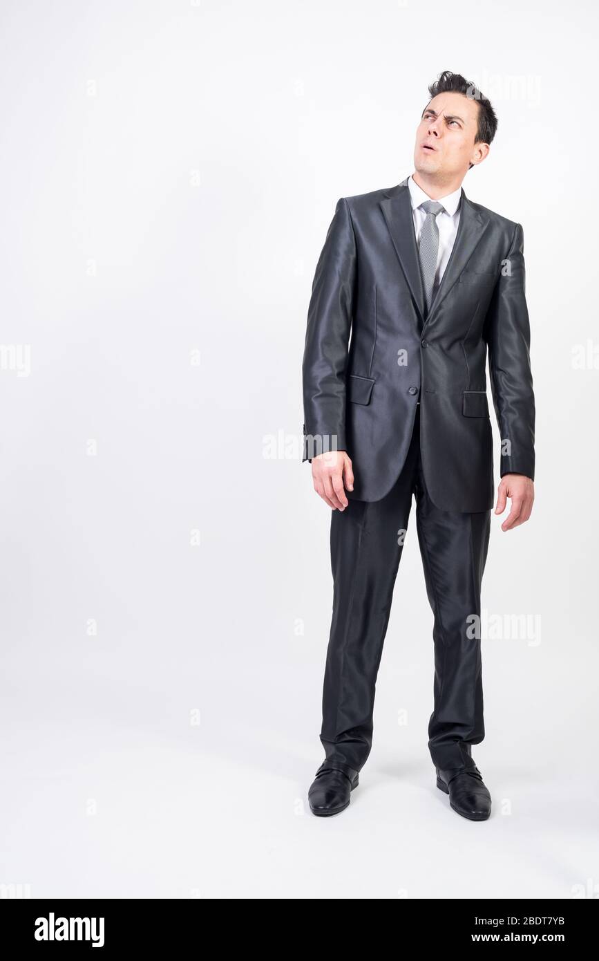 Doubting man in suit. White background, full body Stock Photo - Alamy