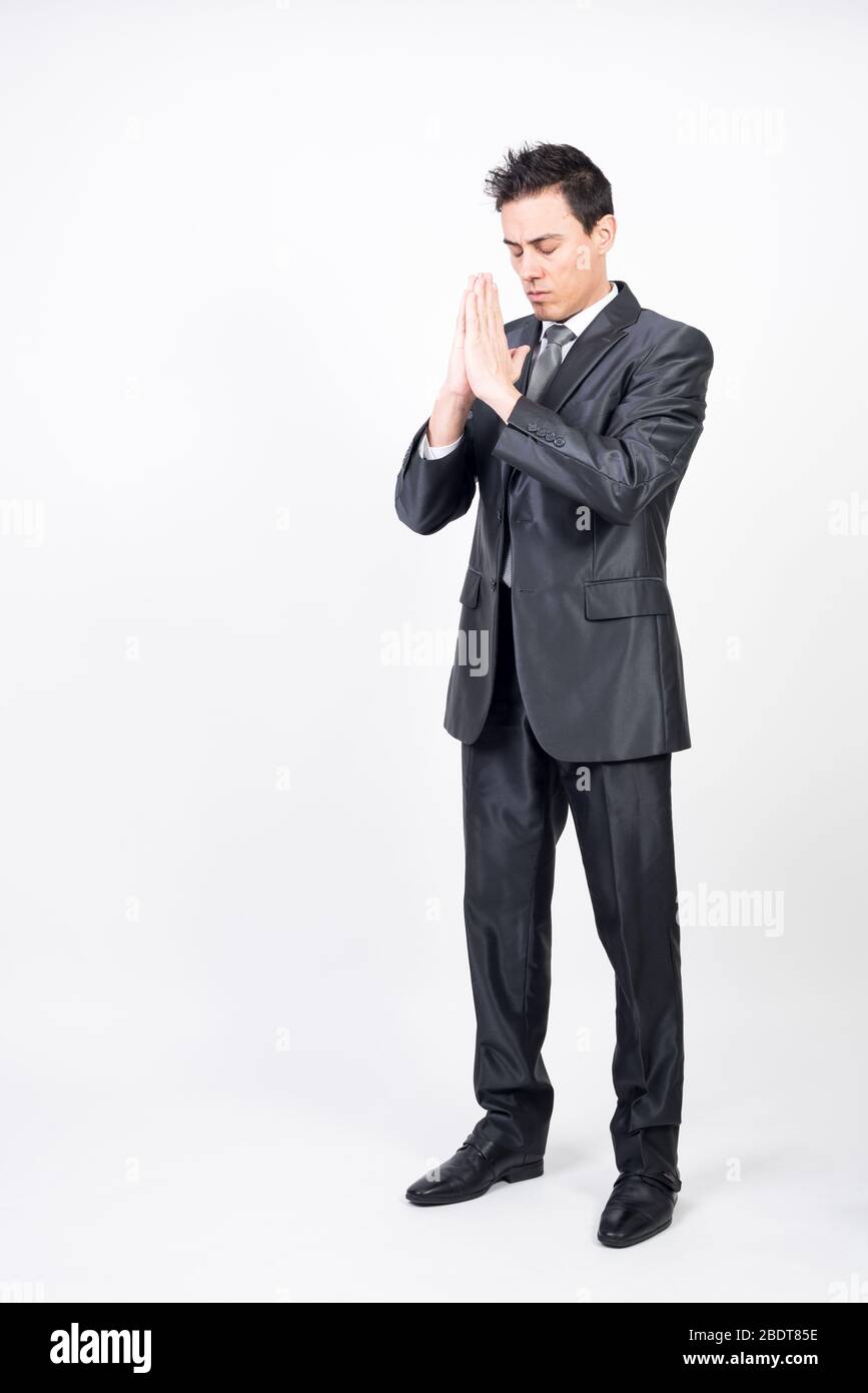Man in suit praying. White background, full body Stock Photo - Alamy