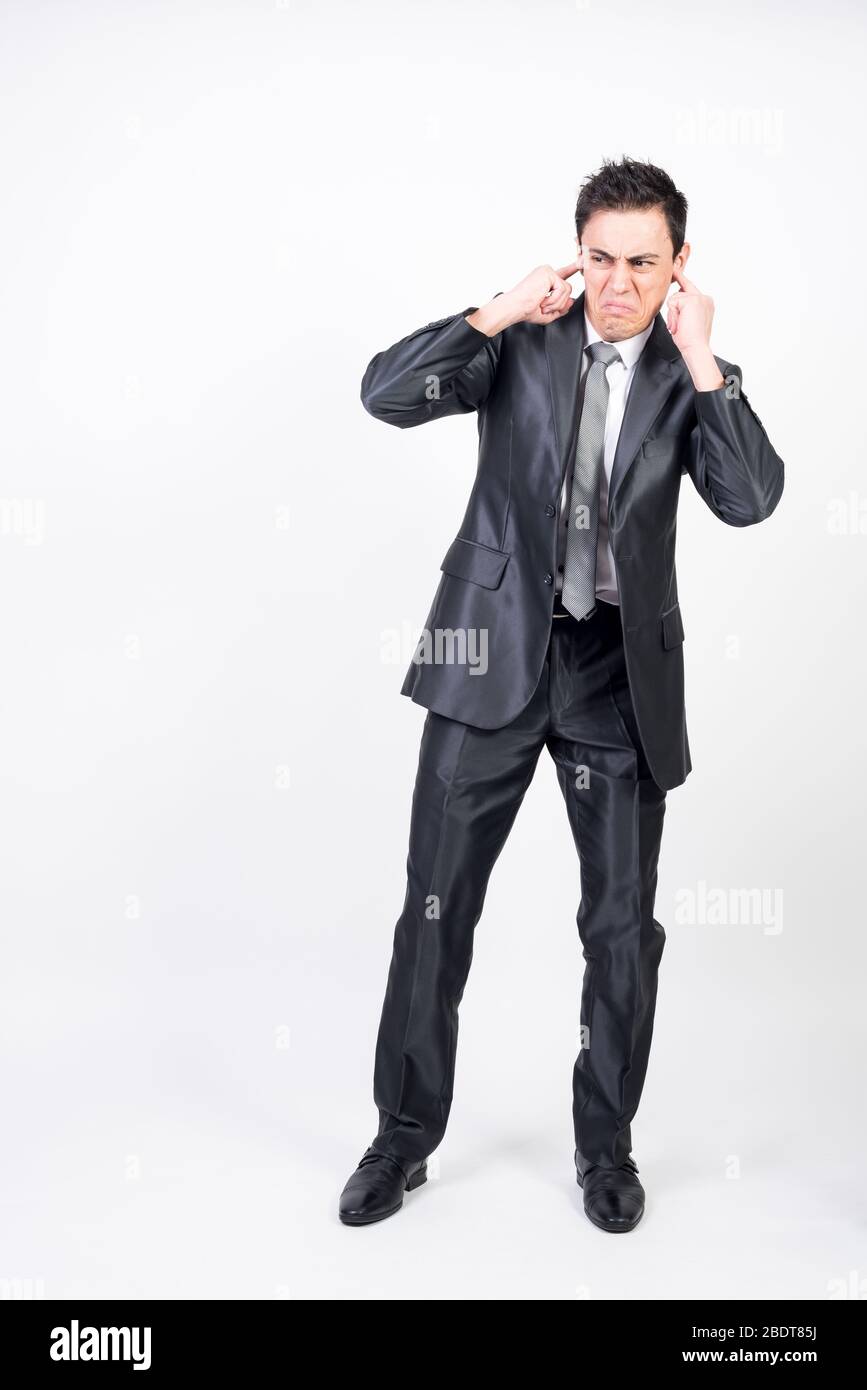 Man in suit disgusted by noise. White background, full body Stock Photo ...