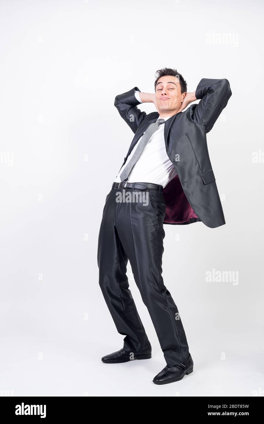 Relaxed man in suit leaning back with his hands on the back of his neck ...