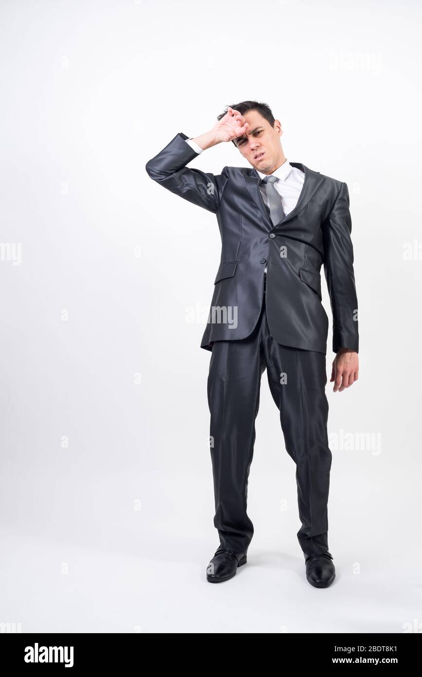 tired man in suit wiping the sweat from his forehead with the back of ...