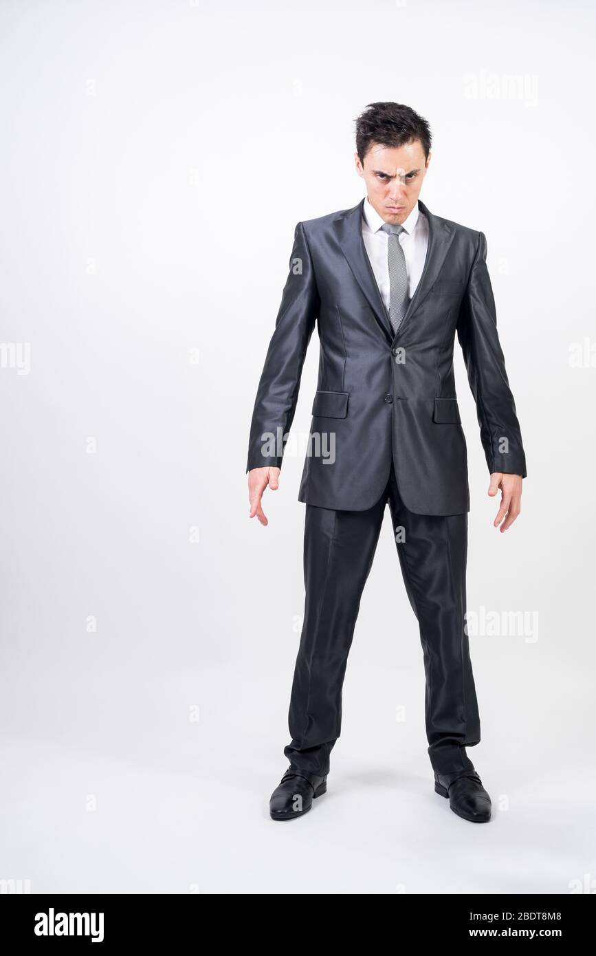 Challenging man in suit. White background. Full body Stock Photo - Alamy