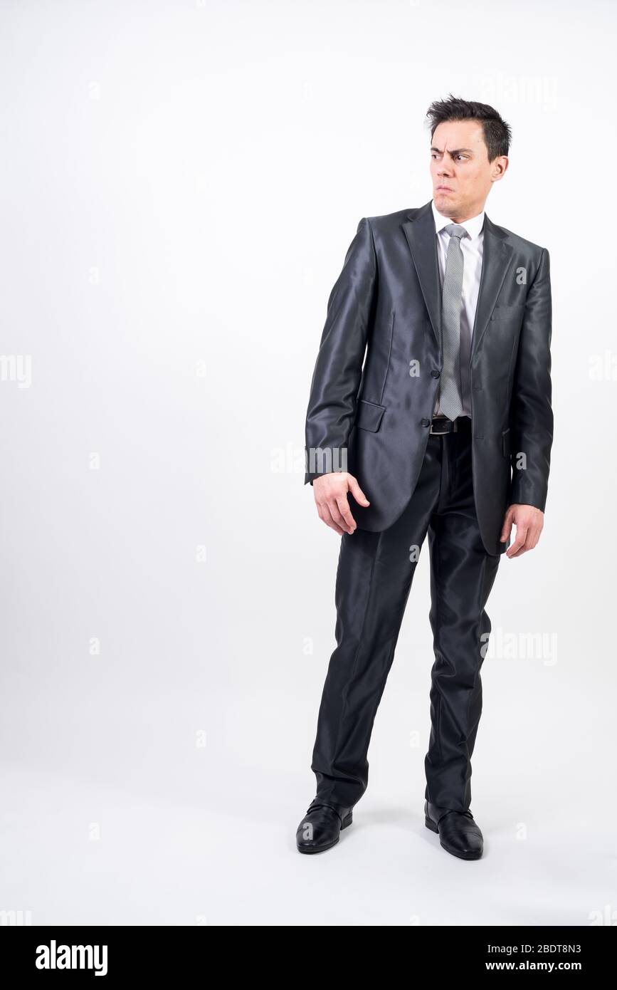 Distrustful man in suit. White background. Full body Stock Photo - Alamy