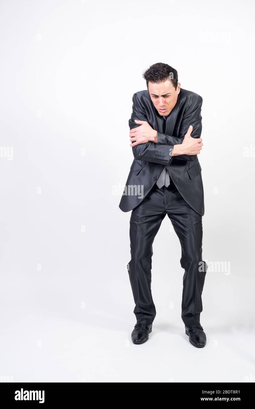 Man in suit getting very cold surrounding his body with his arms. white ...