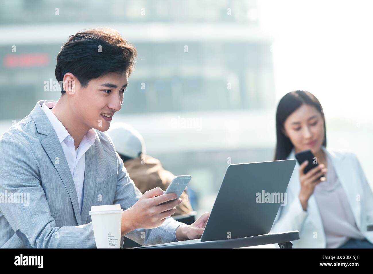 Business people use computers in the open-air cafe Stock Photo - Alamy