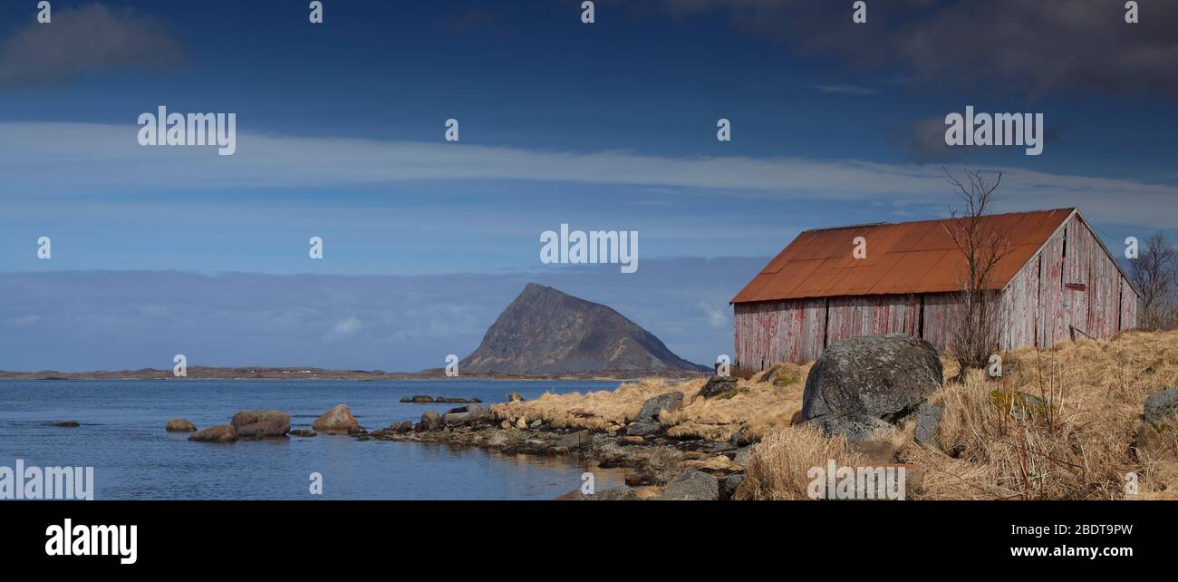 Traditional barn beside mountain lake near Leknes in the Lofoten ...