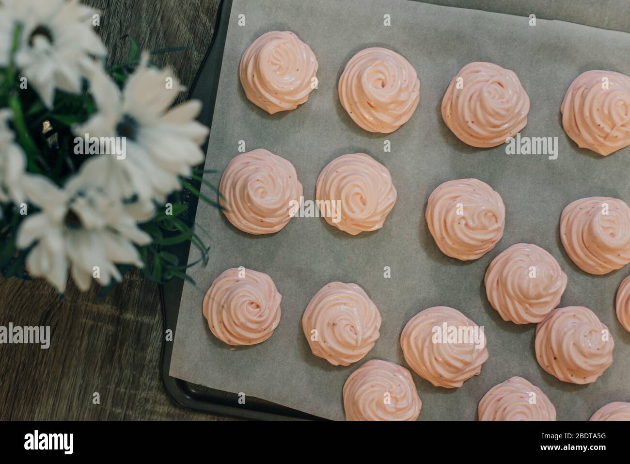 Homemade pink marshmallows on baking paper background on the kitchen ...