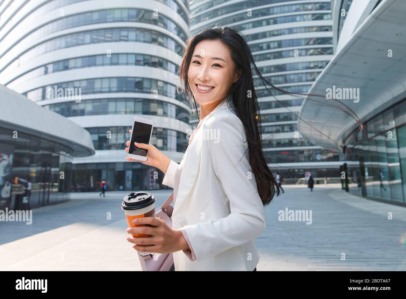 Holding a coffee cup happy business lady Stock Photo - Alamy