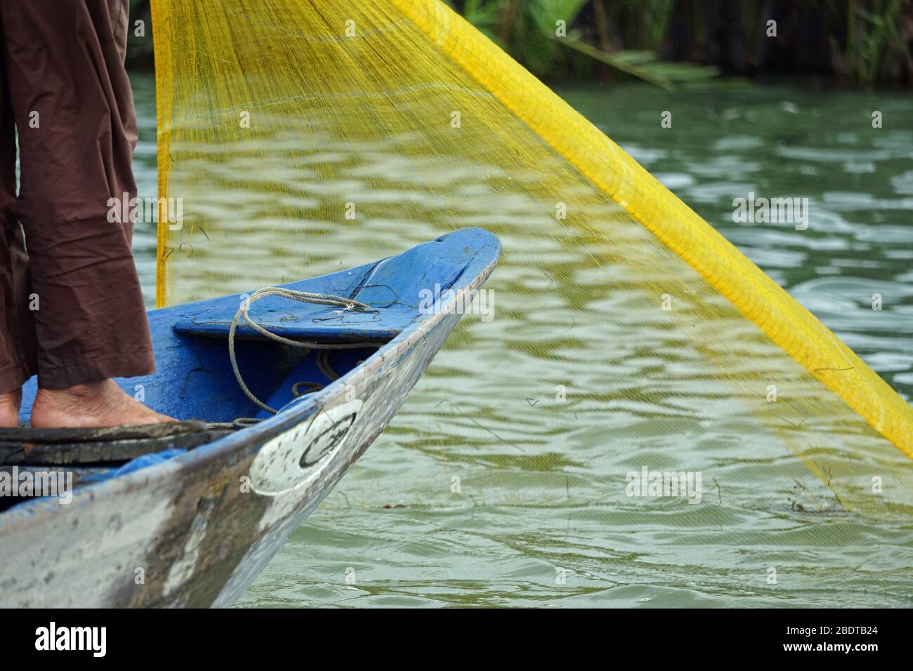vietnamese fisherman on small boat fishing with fishnet Stock Photo - Alamy