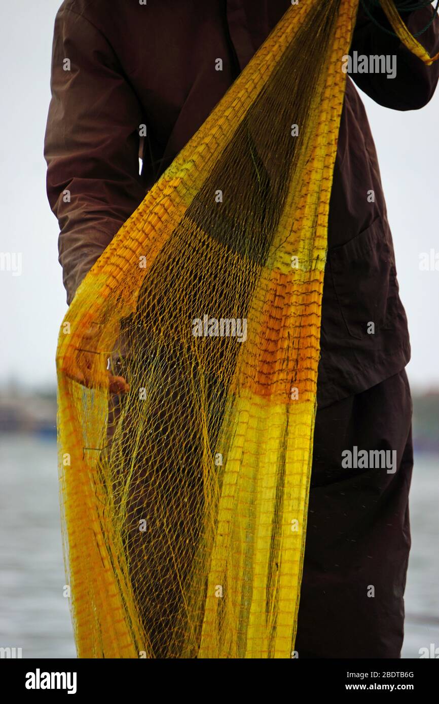 vietnamese fisherman on small boat fishing with fishnet Stock Photo - Alamy