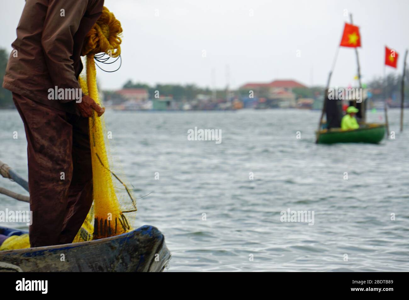 vietnamese fisherman on small boat fishing with fishnet Stock Photo - Alamy
