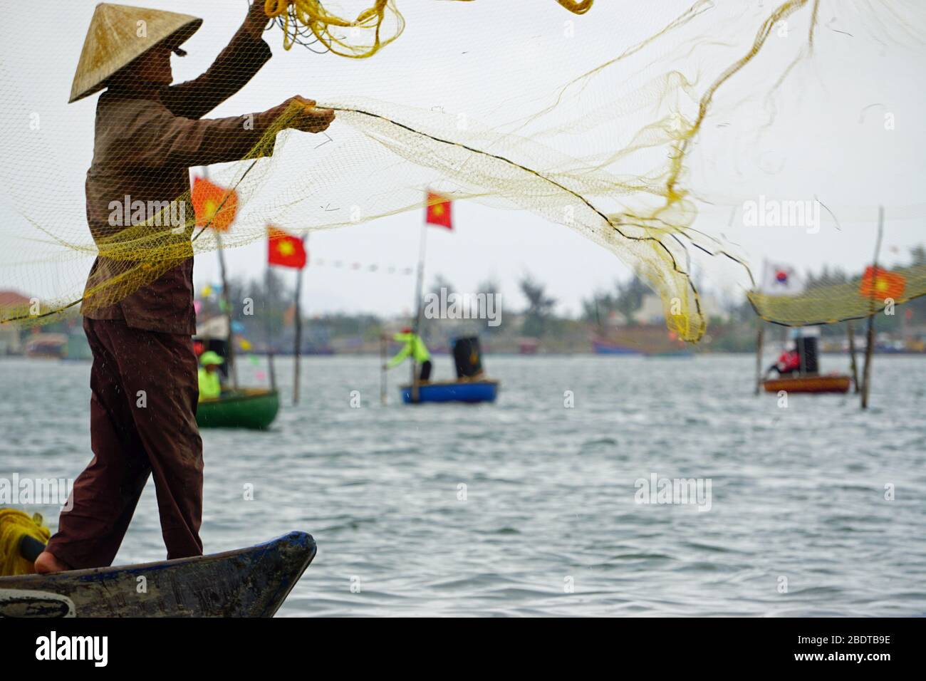 vietnamese fisherman on small boat fishing with fishnet Stock Photo - Alamy
